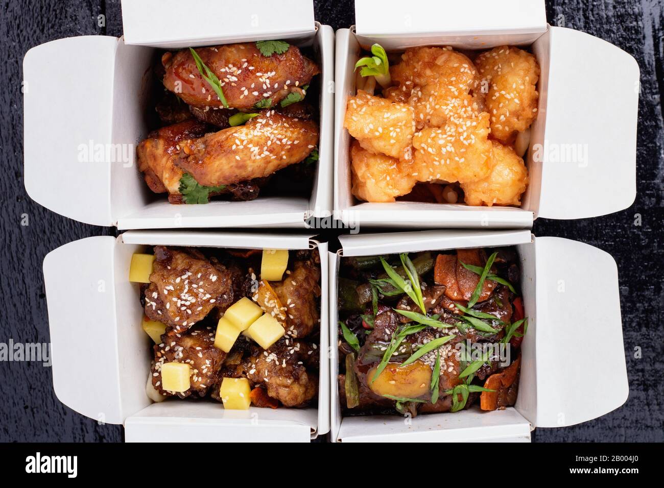 wok food, meat and noodles into four paper boxes, top view, plastic ...