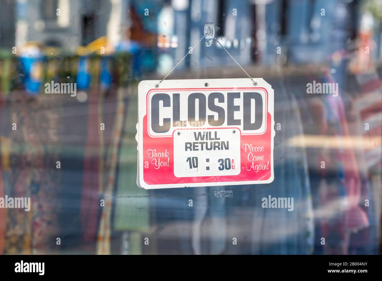 A temporary closed or closed overnight sign in a clothing shop window ...