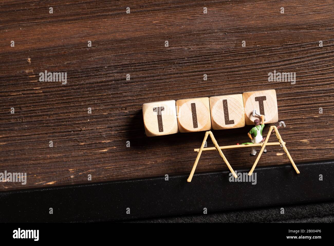 little painter figure and word TILT on cubes on wooden background Stock ...