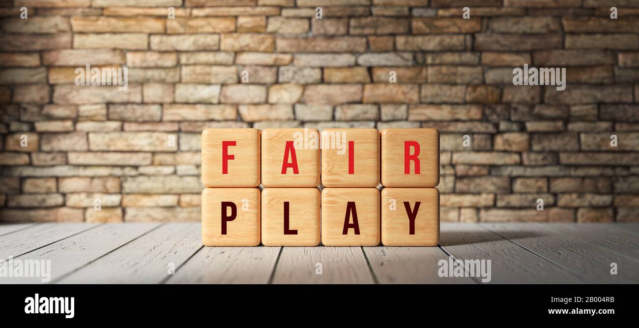 cubes with the message "fair play" in front of a brick wall on wooden ...