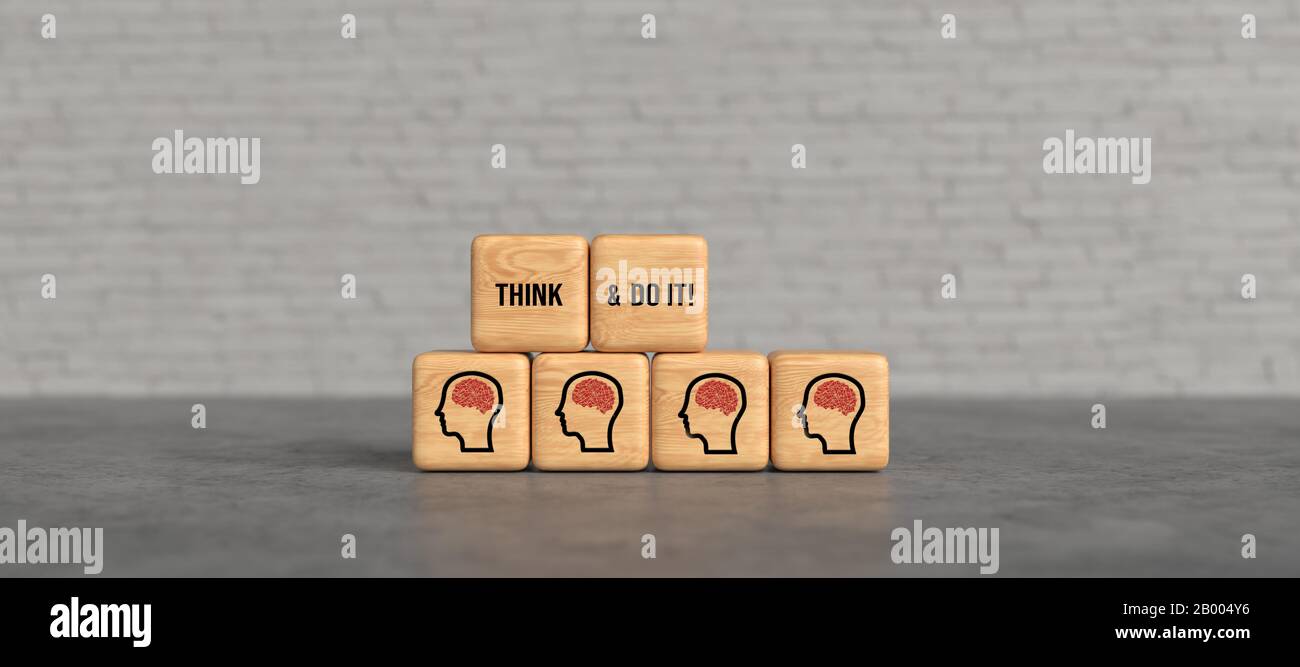 cubes with message THINK & DO IT on conrete floor in front of a brick ...