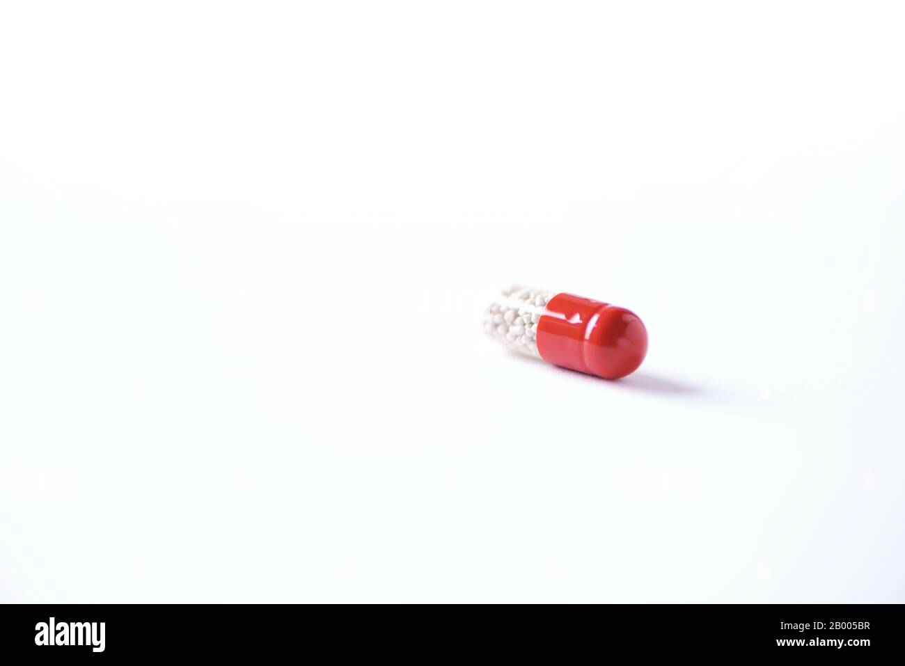 Macro of red capsules on white background. Copy space. Bunch of drugs ...
