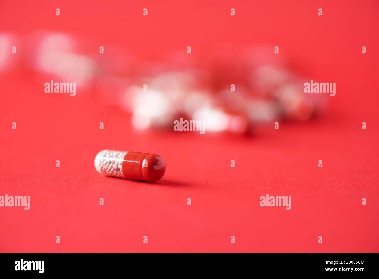 Macro of red capsules on red background. Copy space. Bunch of drugs ...