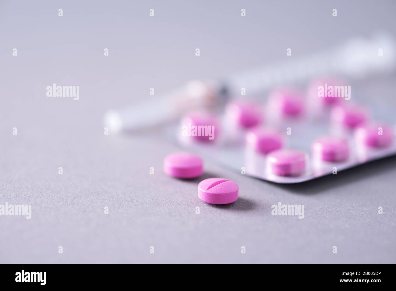 Pink capsule, pills, vitamins on grey background. Copy space. Bunch of ...