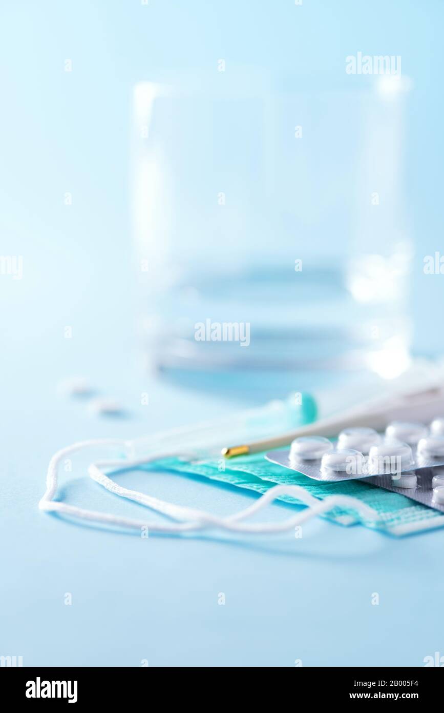 Concept of flu treatment - pills, capsules, thermometer, protective ...