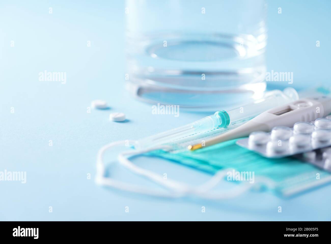 Concept of flu treatment - pills, capsules, thermometer, protective ...
