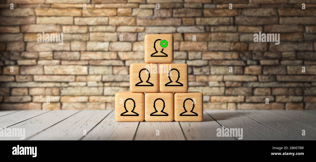 cubes with person-symbols stacked as a pyramid in front of a brick wall ...