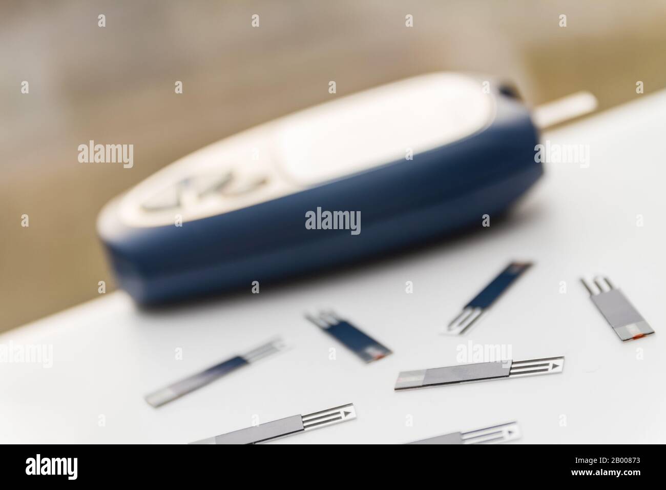 Used test strips with glucometer on the background. Blood glucose meter ...