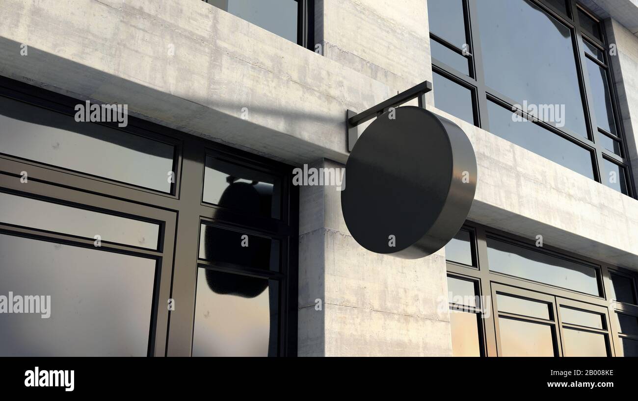 A round black sign mounted outside a generic unbranded shop facade on ...