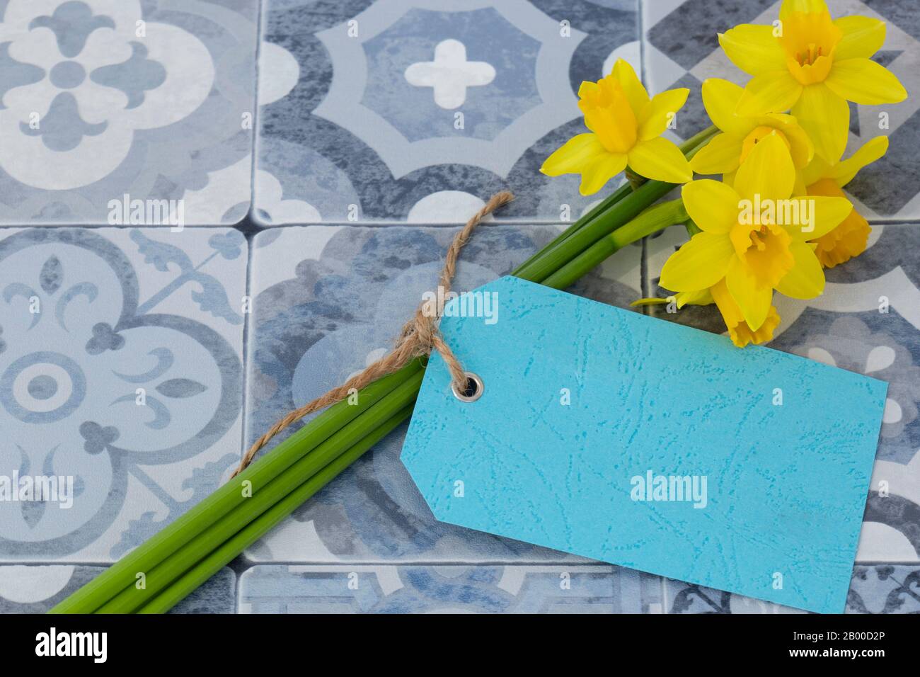 Bunch of daffodils narcissus tied with string with a blank blue label ...