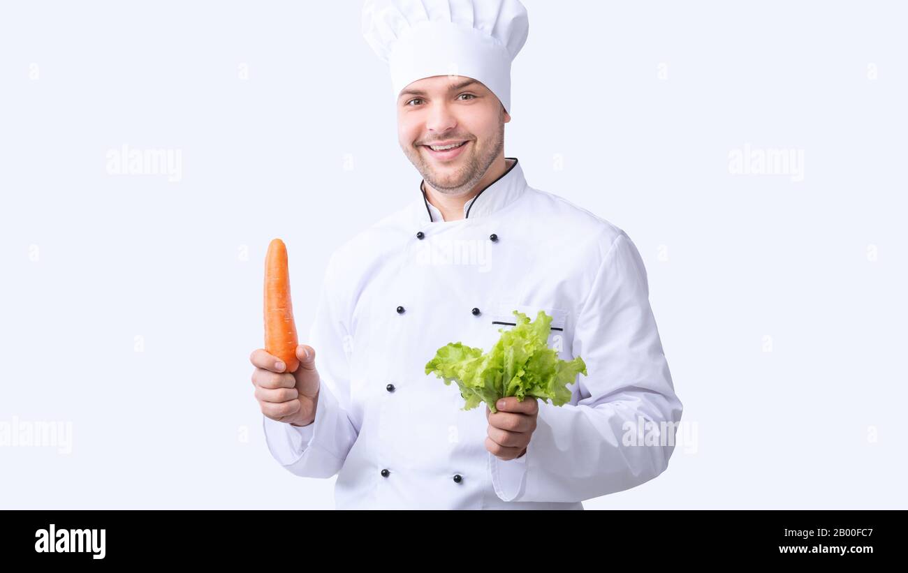 Chef Guy Holding Carrot And Green Salad, Studio Shot, Panorama Stock ...
