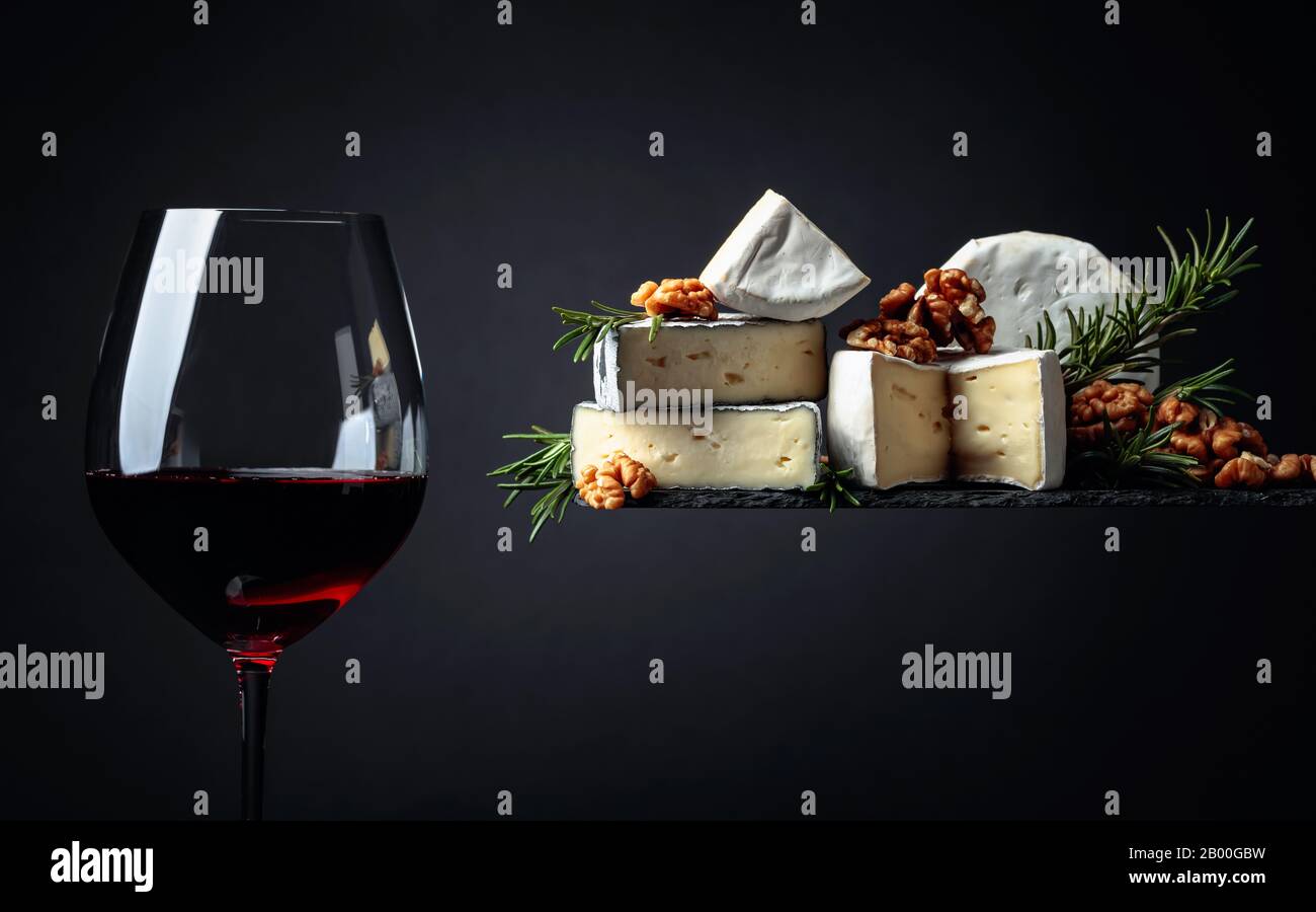 Red wine and soft cheeses with walnuts and rosemary. Copy space Stock ...