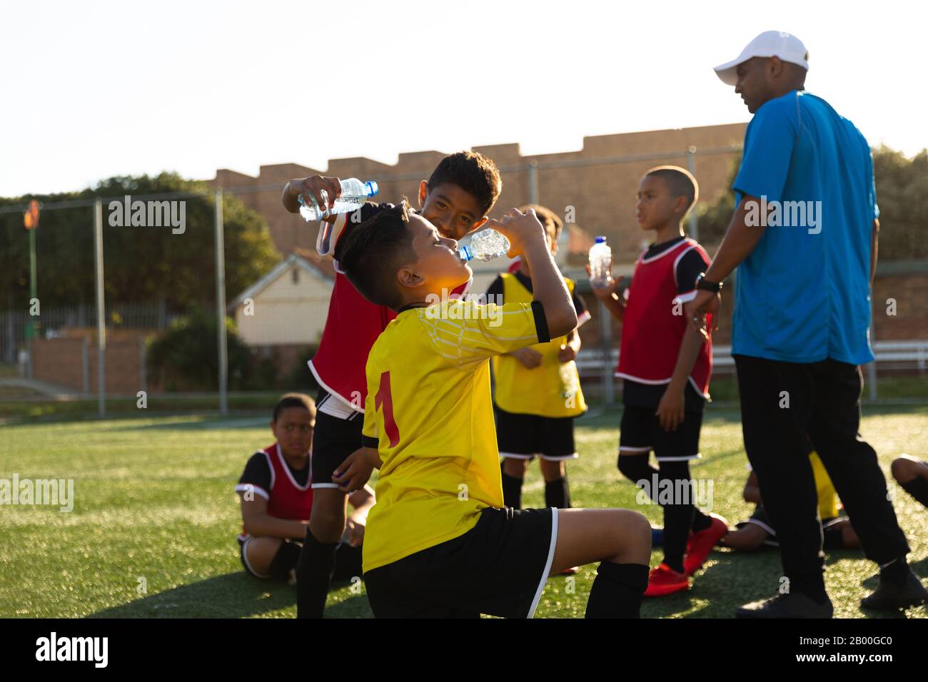 Soccer team resting and drinking water Stock Photo - Alamy