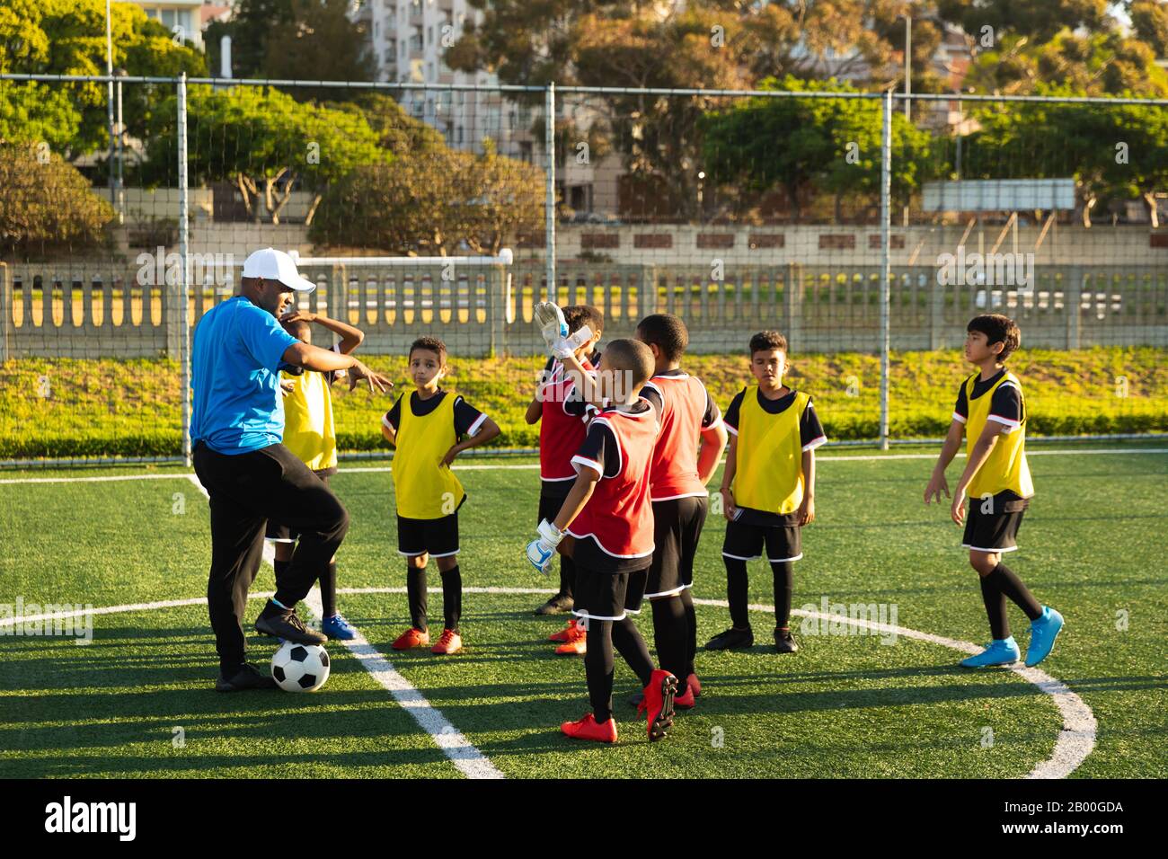 Soccer players and coach talking on the field Stock Photo - Alamy
