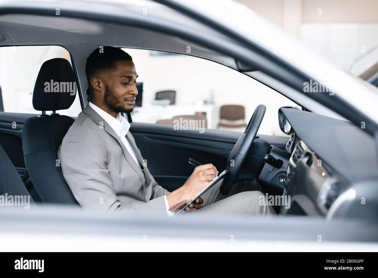Car Seller Taking Notes Sitting In Automobile In Dealership Store Stock ...