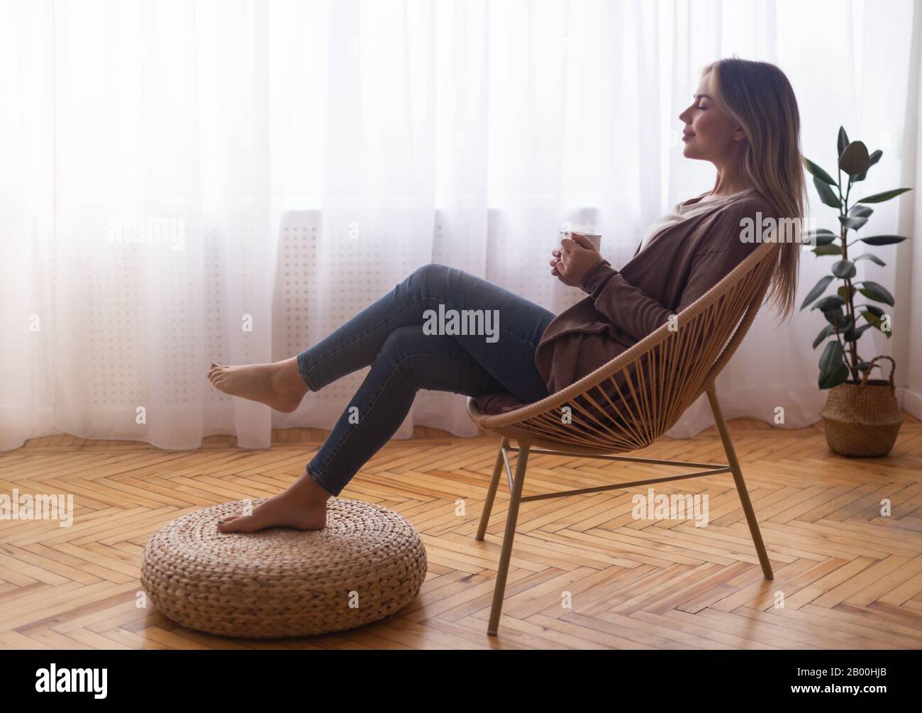 Calm girl drinking coffee, relaxing near window at home Stock Photo - Alamy