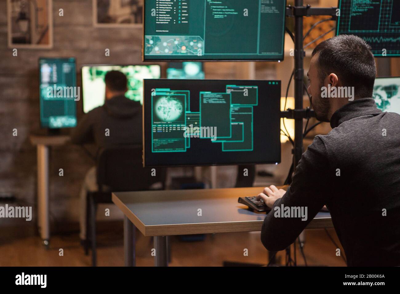 Back view of hackers working on making a dangerous malware on computers ...