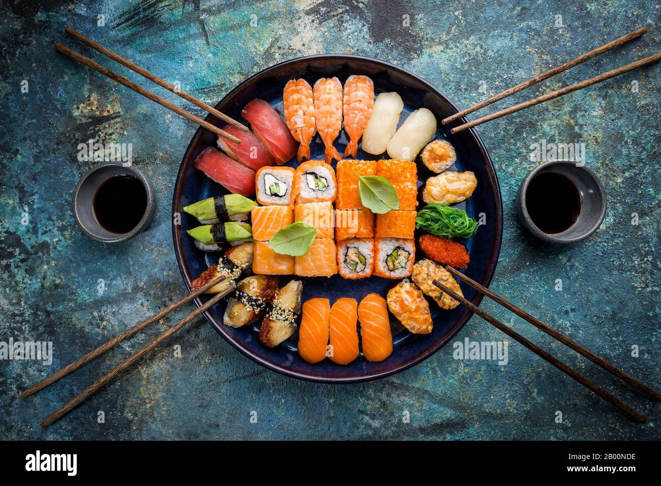 Set of sushi and maki with soy sauce over blue stone background. Top ...