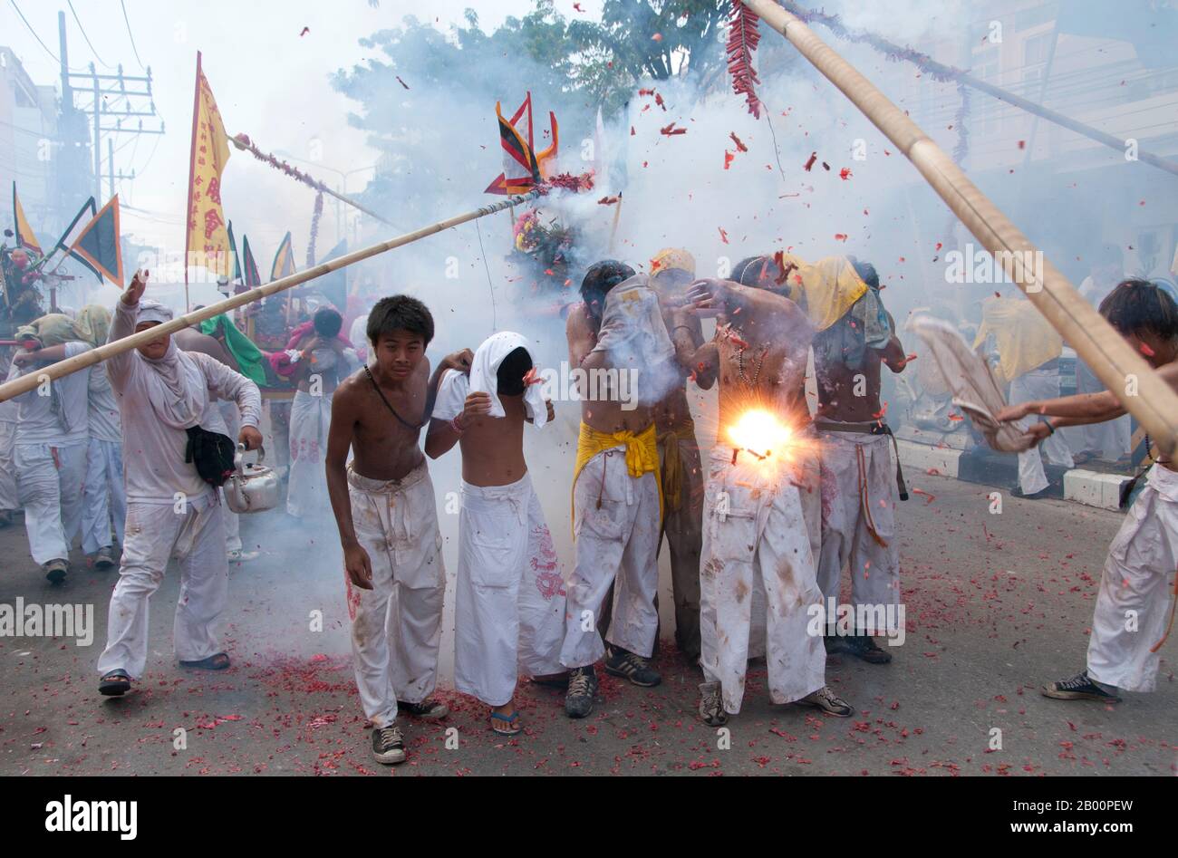Thailand: Shop owners wave bamboo poles with strings of exploding ...