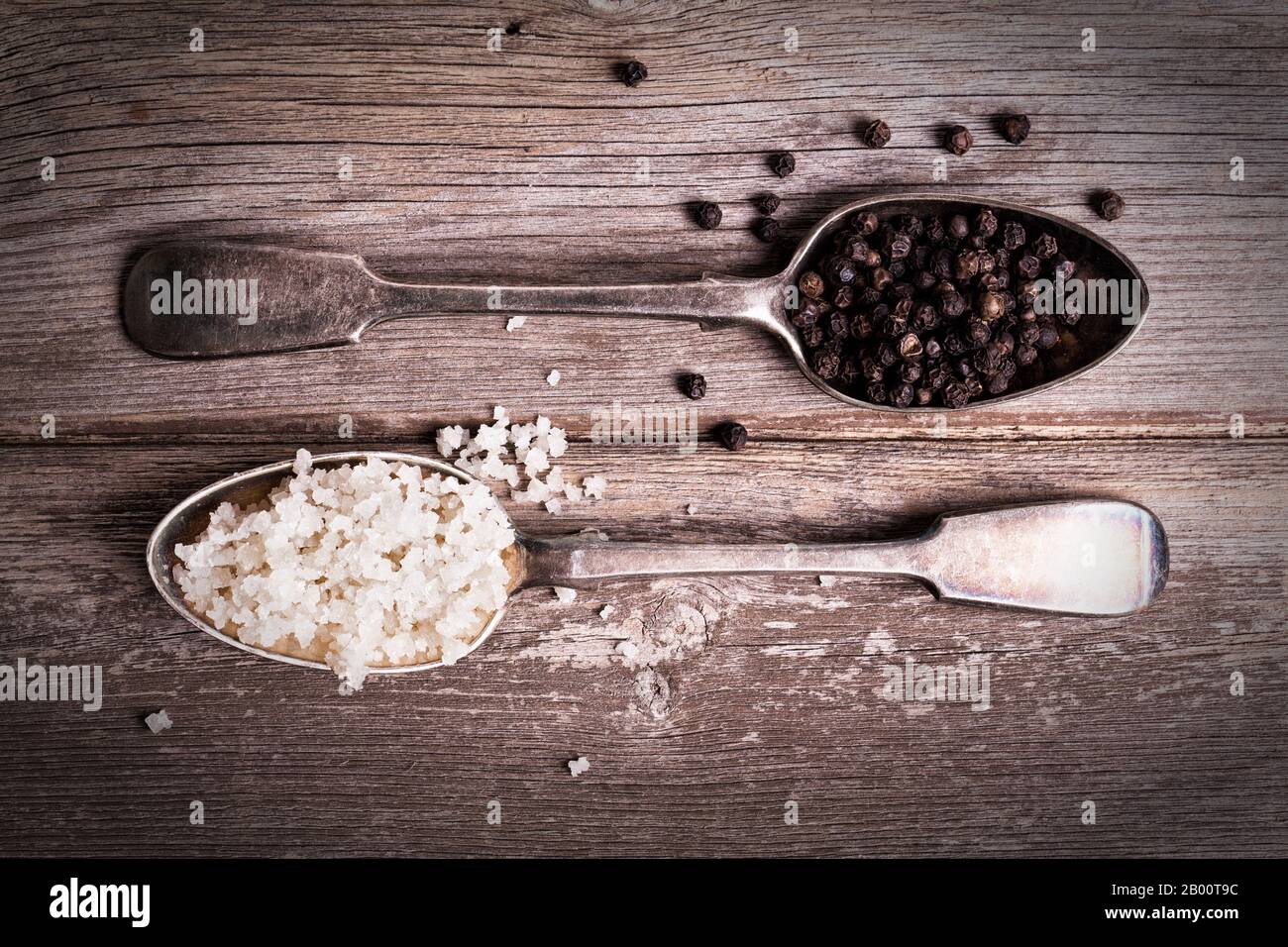 Vintage effect image of tarnished silver spoons filled with salt ...