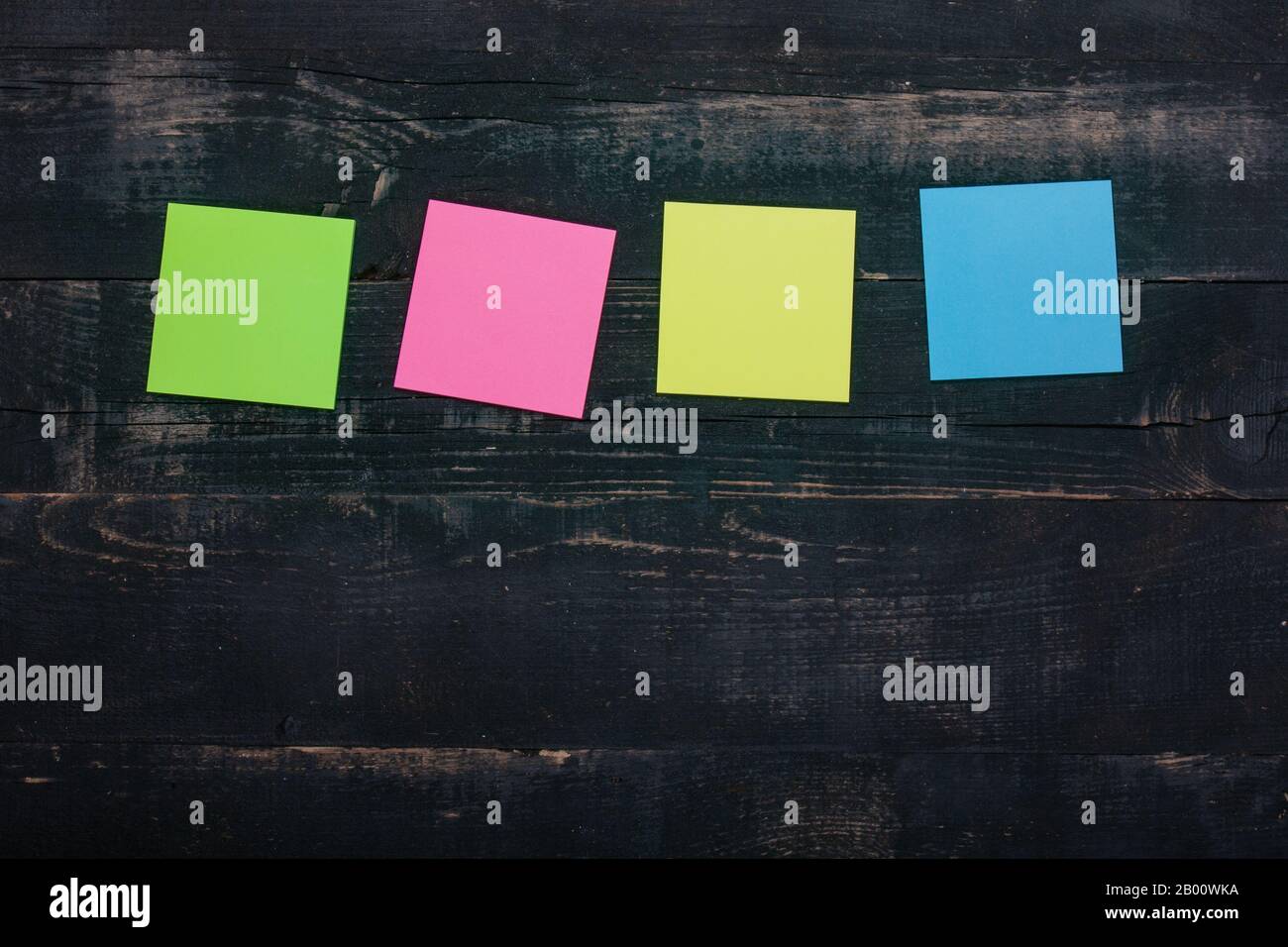 Multicolored paper reminders on a wooden background Stock Photo - Alamy