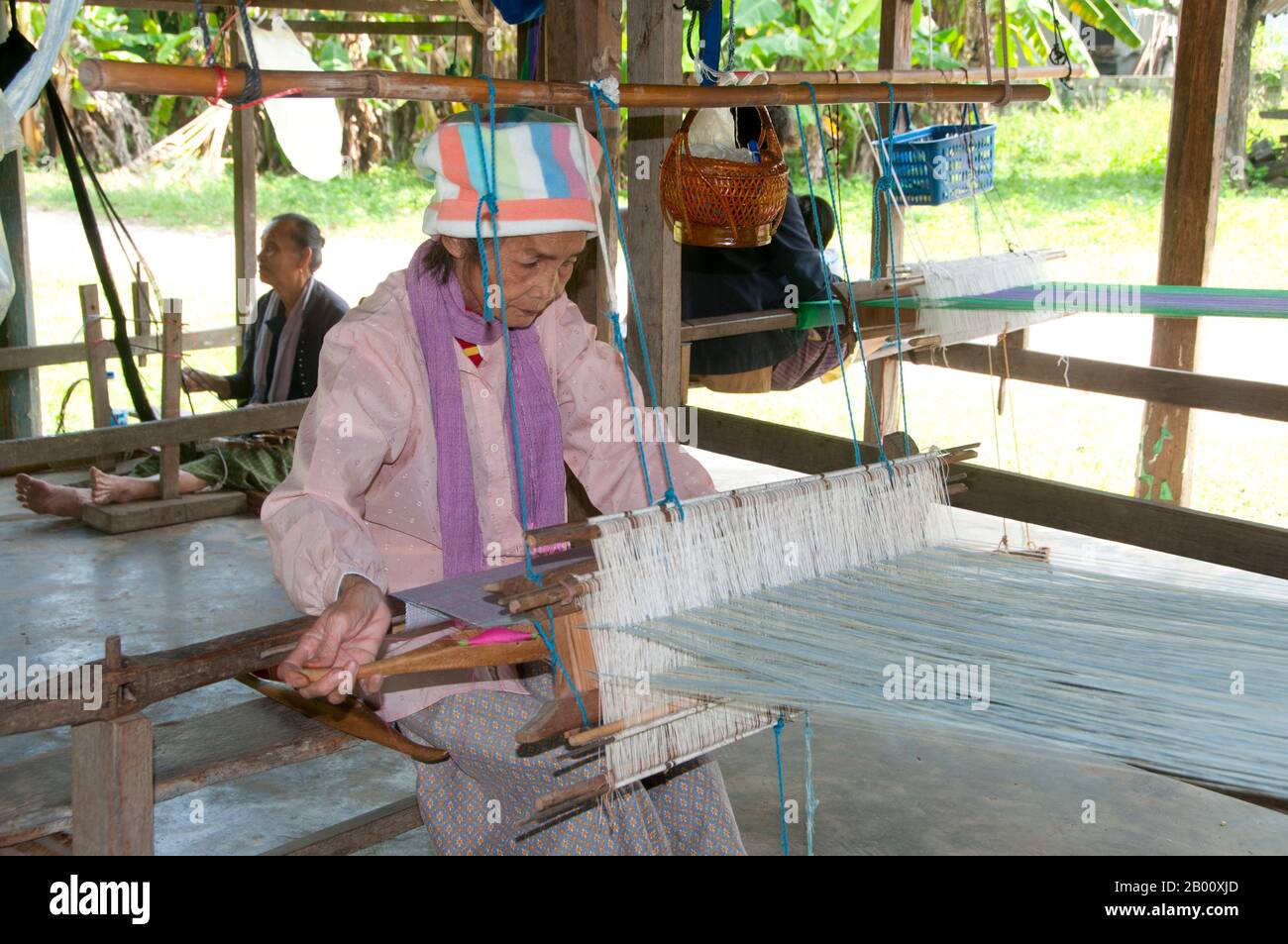 Thailand: Weavers sit below a traditional Tai Dam house, Ban Na Pa Nat ...