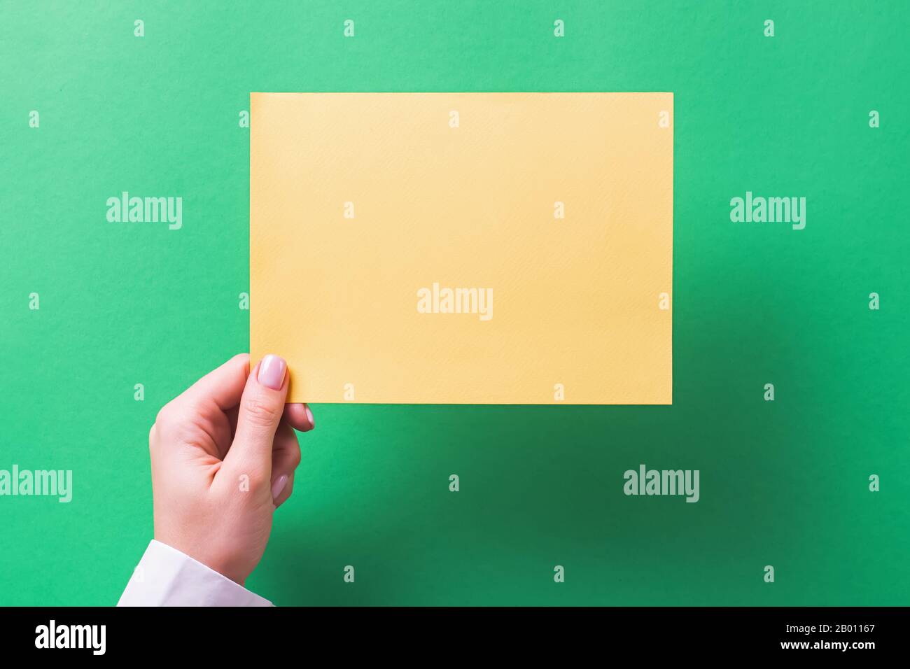 Woman's hand holding blank yellow color note paper Stock Photo - Alamy