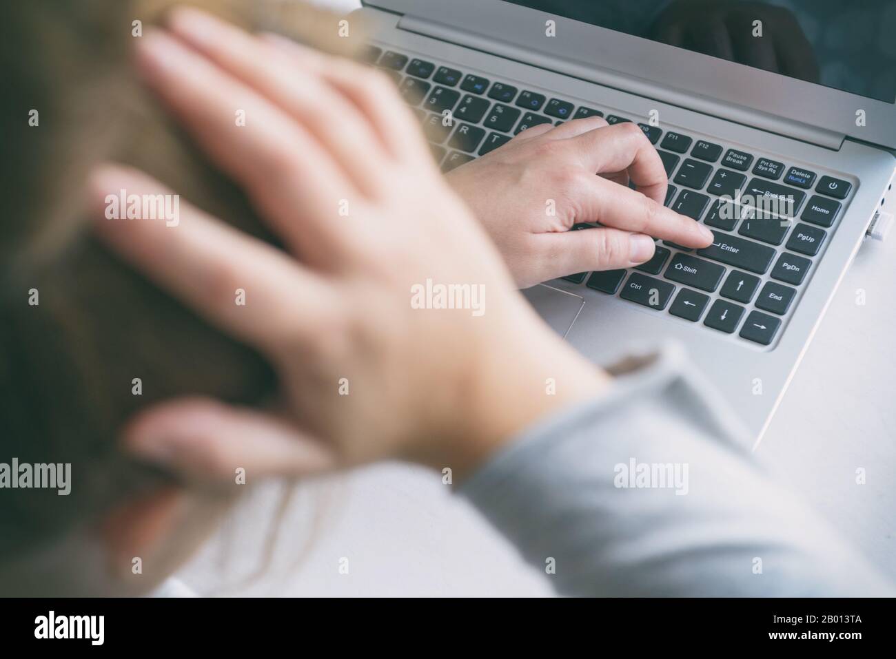 Back view of stressed businesswoman touching head with hands and ...