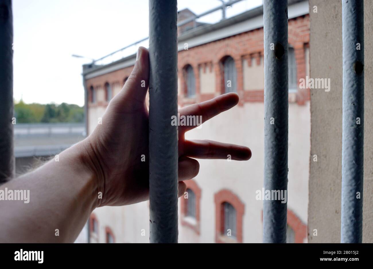 Prison cell bars hand hi-res stock photography and images - Alamy