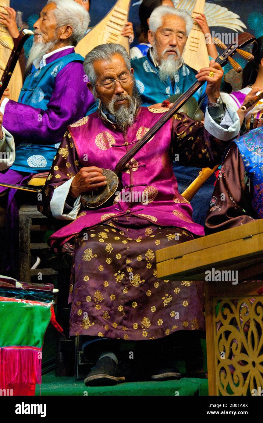 China: A man plays a sanxian, the Naxi (Nakhi) Folk Orchestra, Naxi ...