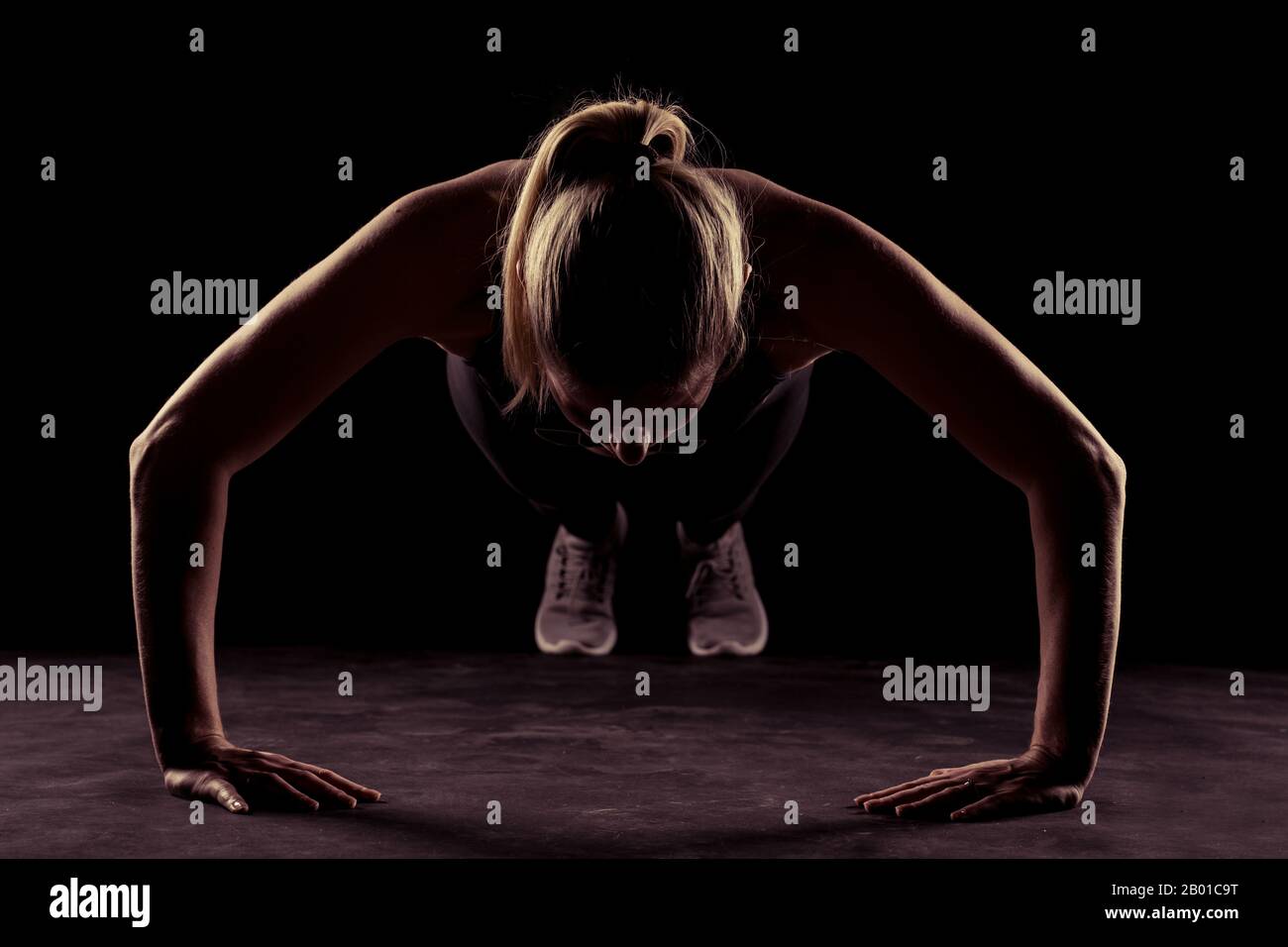 Fit female model in sport clothing doing exercises in the studio with ...