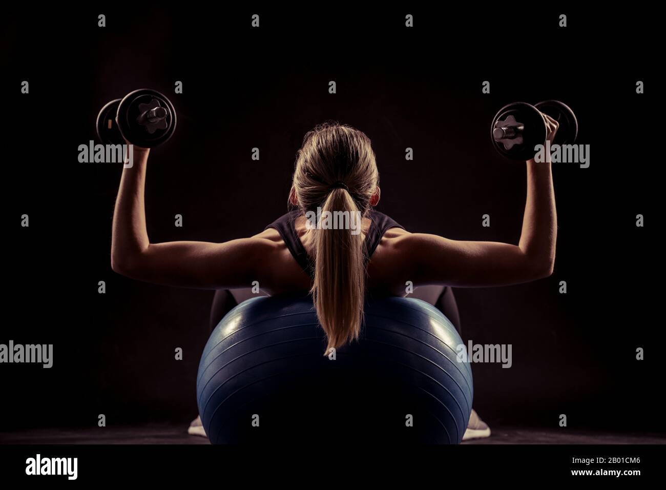 Fit female model in sport clothing doing exercises in the studio with ...