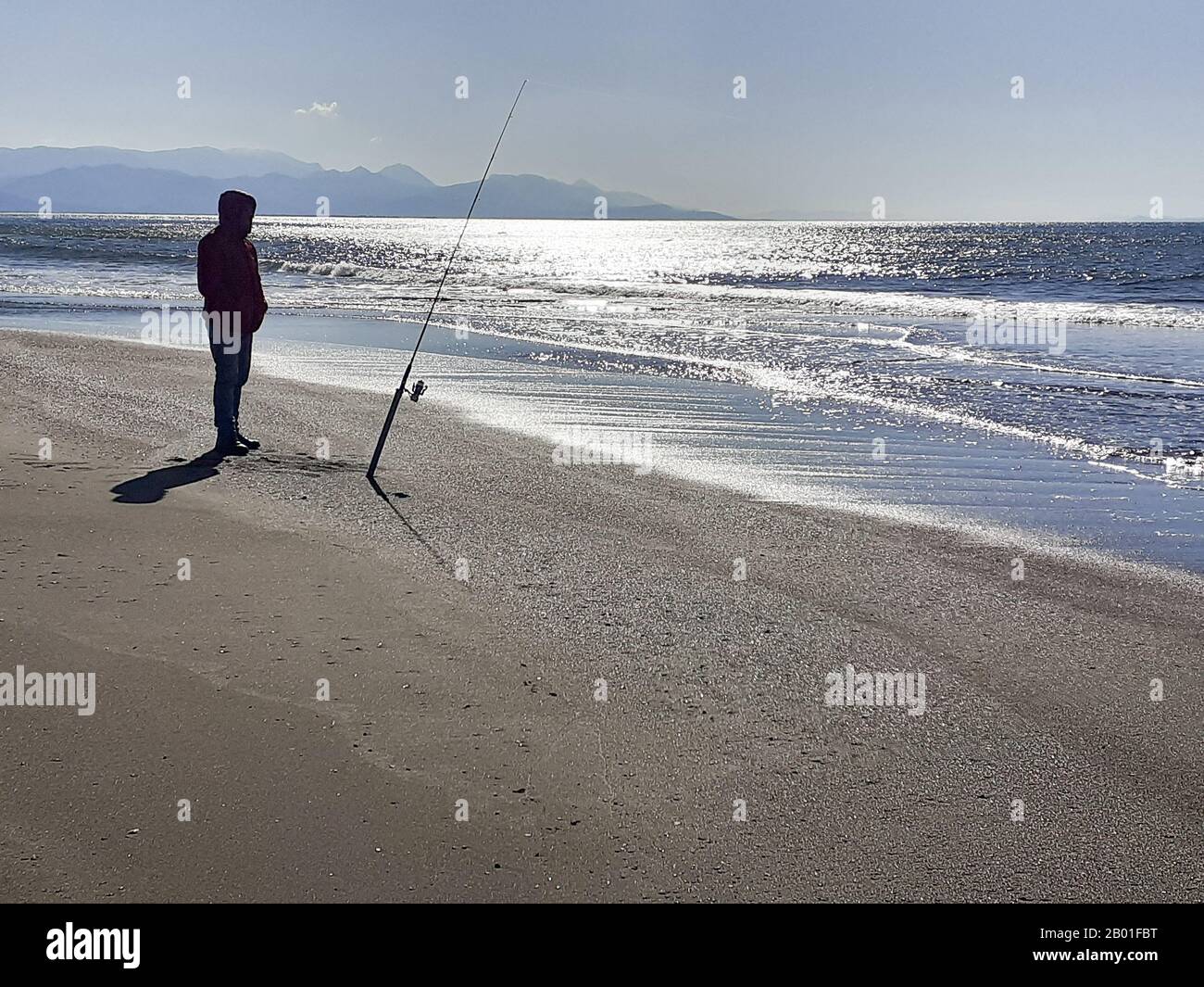 Fishing man on the sea shore Stock Photo - Alamy