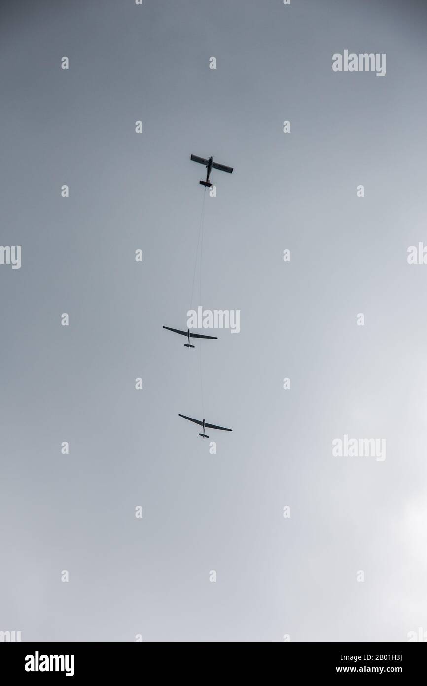 Motor pilot drags two glider pilots into the air Stock Photo - Alamy