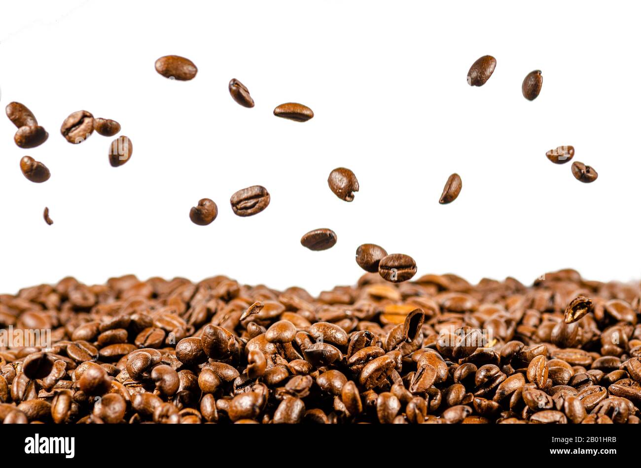 coffee beans fall on a heap of coffee beans, white background, isolated ...