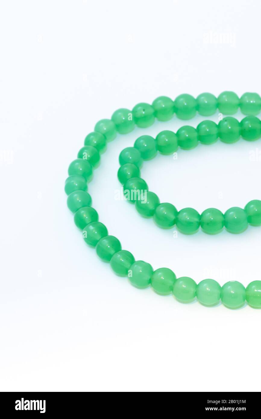 Green nephritis beads isolated on white background Stock Photo - Alamy