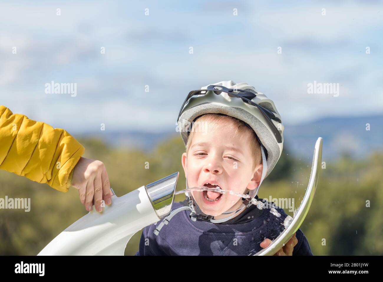 Young boy drinking water from public street bubbler in Adelaide city ...
