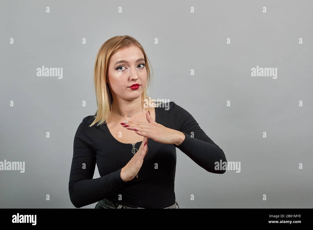 Young girl in black jacket stylish woman demonstrates the sign of break ...