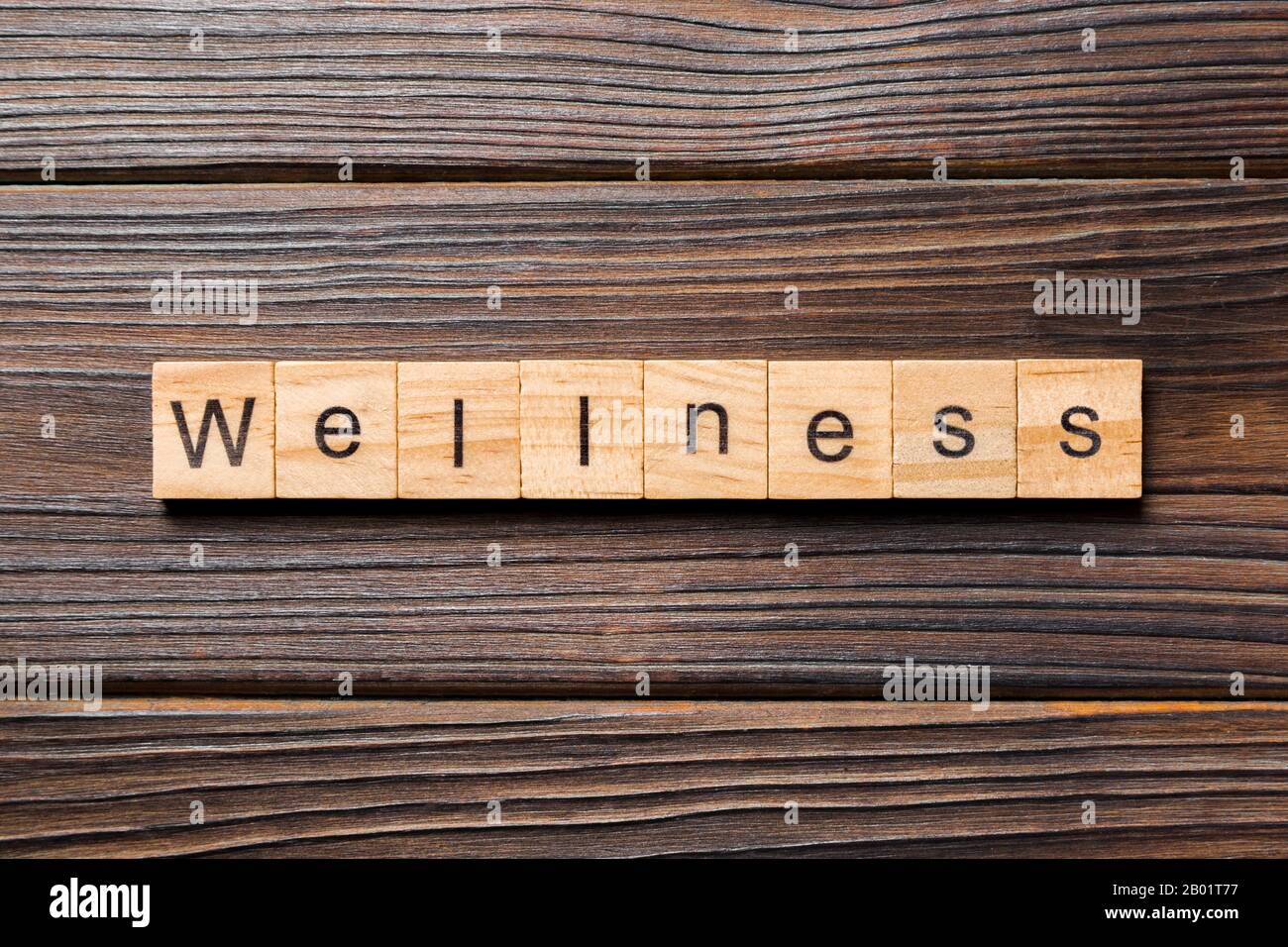 Wellness word written on wood block. Wellness text on wooden table for ...