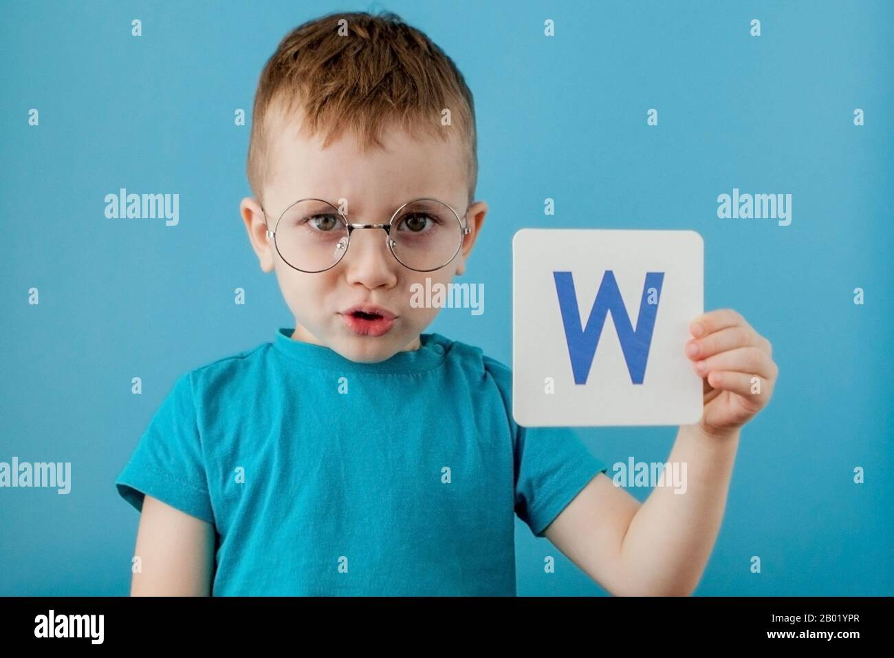 Cute little boy with letter on blue background. Child learning a ...