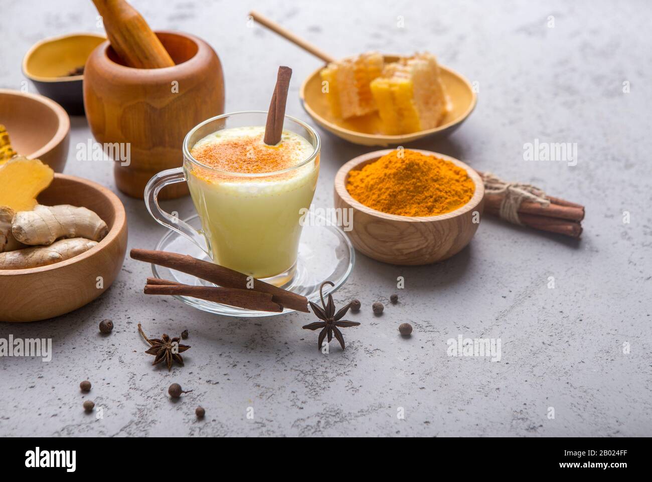 Turmeric powder, curcuma root, cinnamon, ginger over grey Stock Photo ...