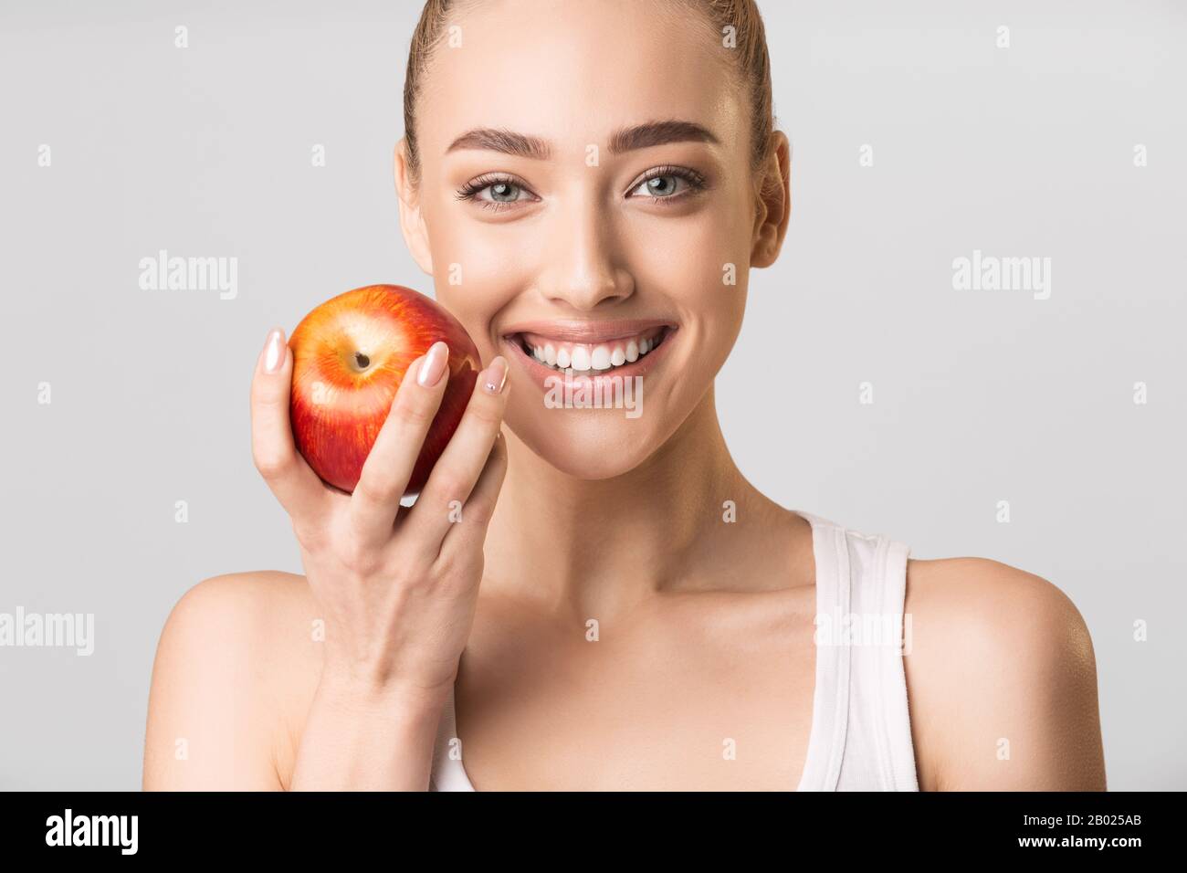 Woman With Perfect Smile Holding Apple Posing On Gray Background Stock ...