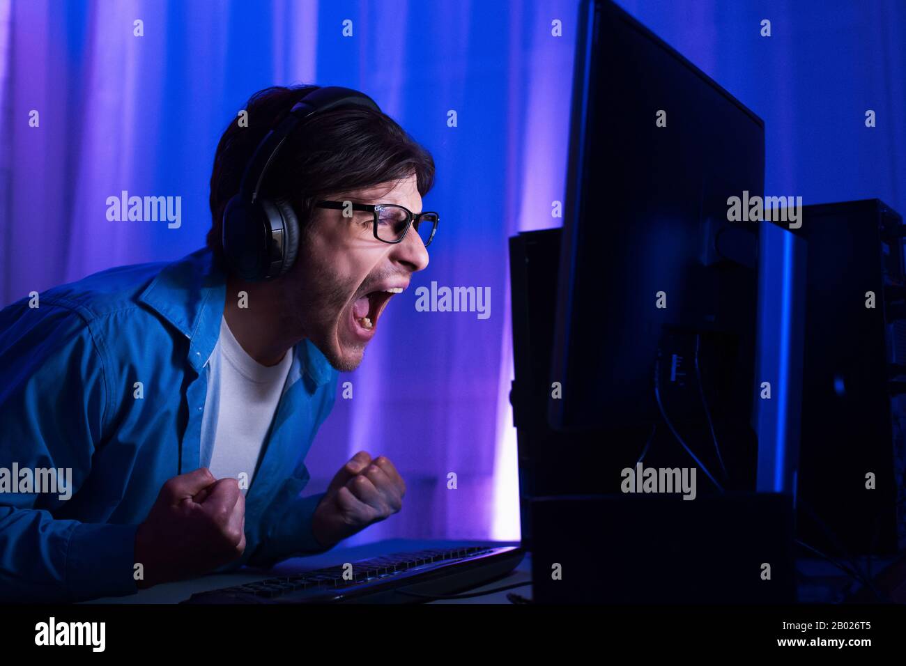Emotional Gamer At PC Celebrating Victory At Home At Night Stock Photo ...