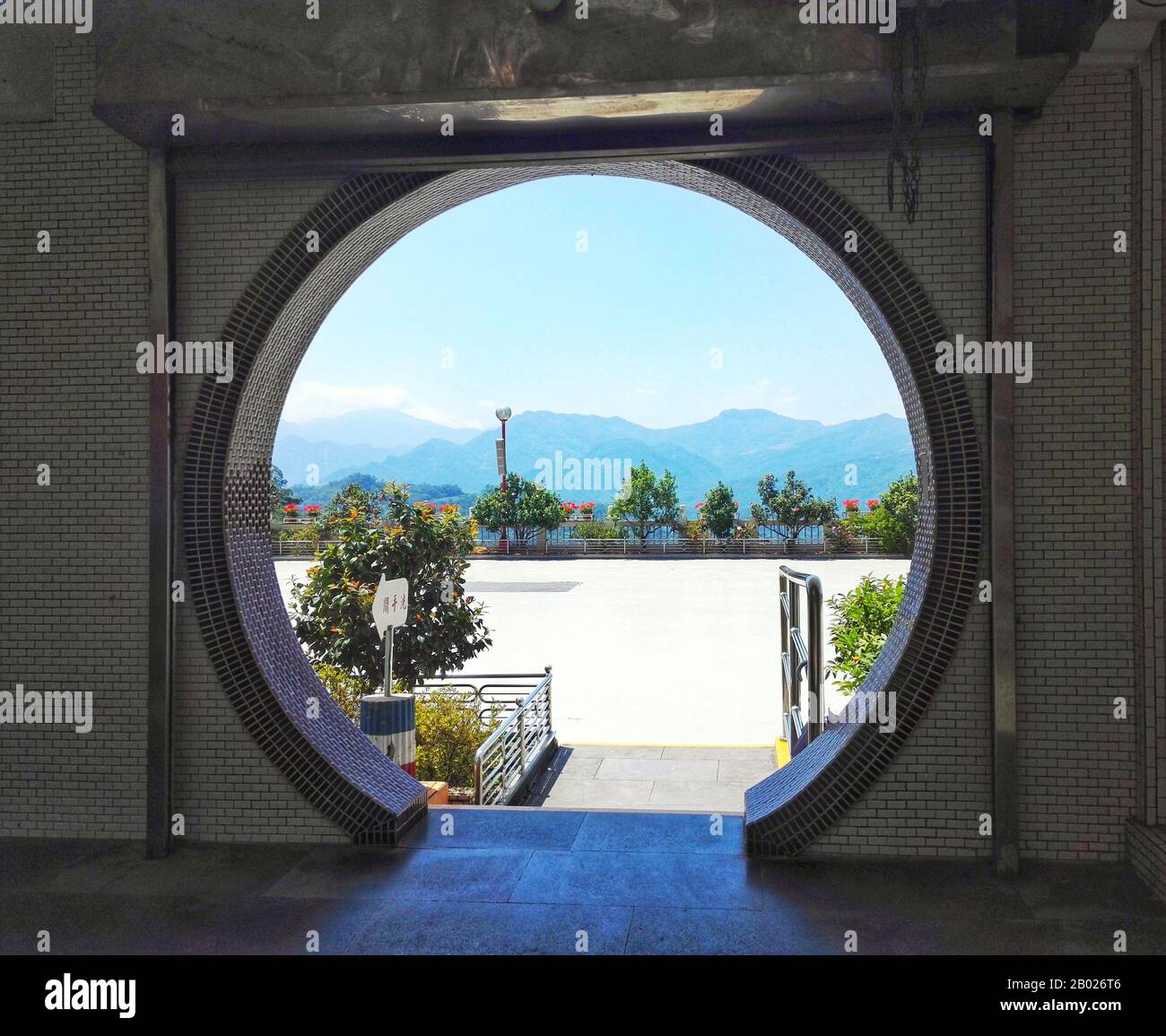 Scenic Chinese round gate, view over mountain range in background Stock ...