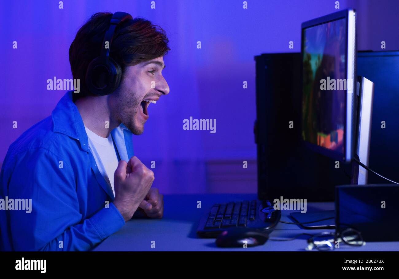 Excited Gamer Winning Computer Game Celebrating Sitting At PC Indoor ...