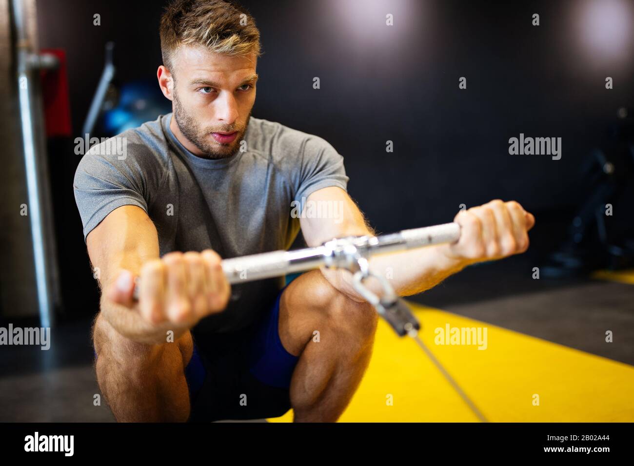 Fit happy man exercising at the gym on a machine Stock Photo - Alamy