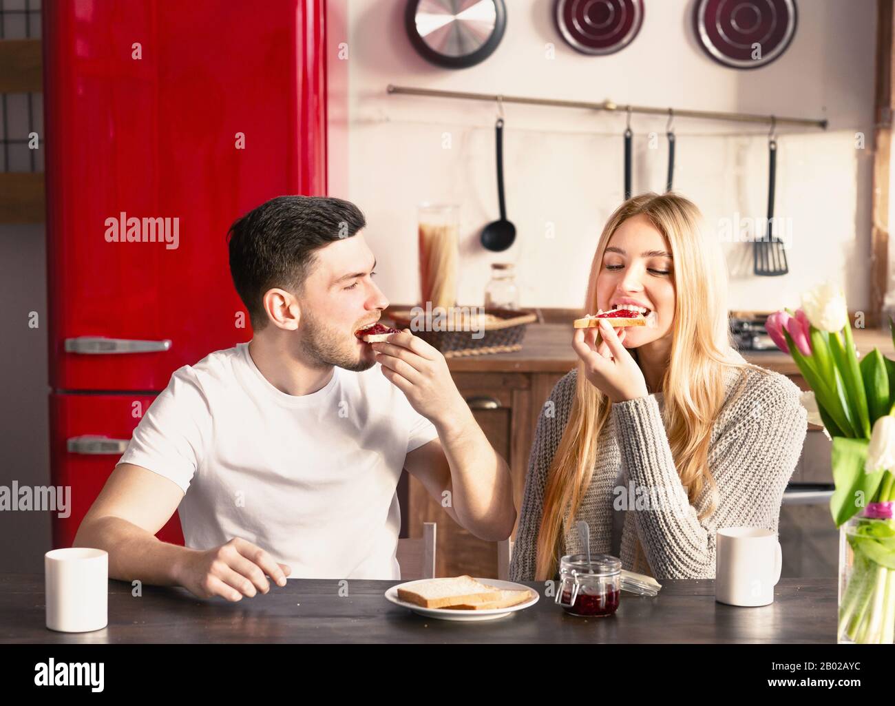 Cheerful millennial couple having breakfast with tasty sandwiches Stock ...