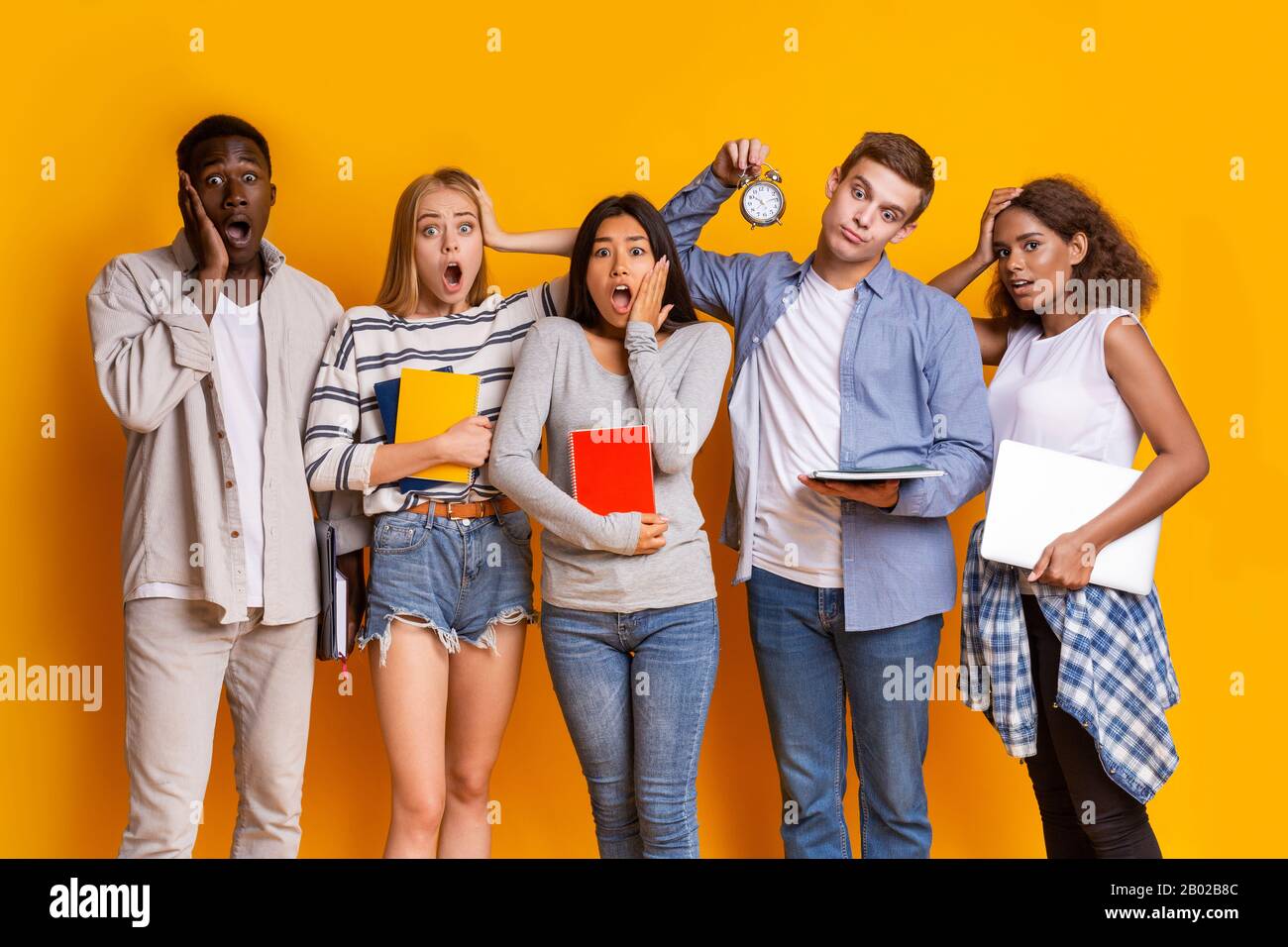 Stressed group of international students holding alarm Stock Photo - Alamy