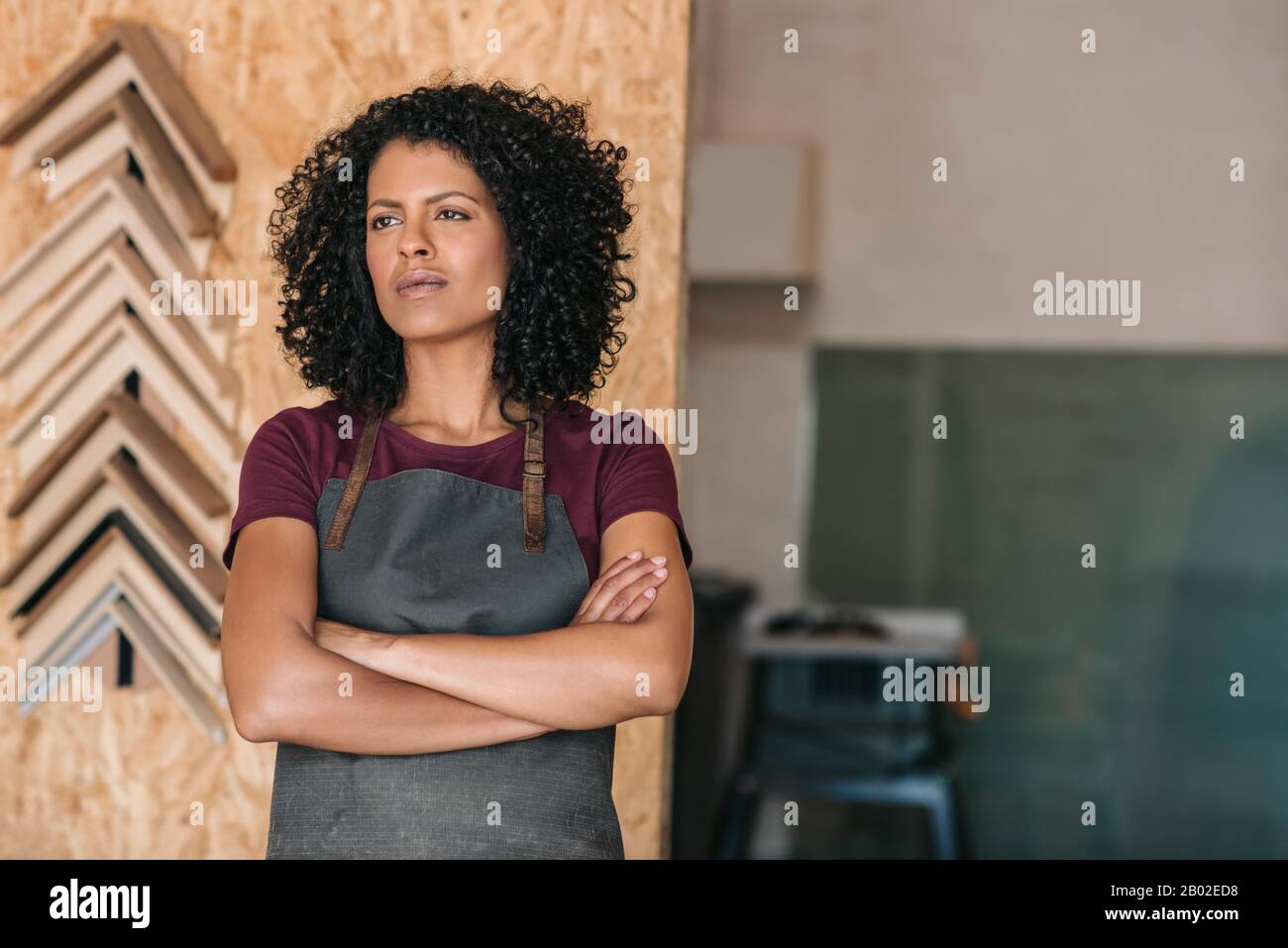 Confident young woman standing in her picture framing workshop Stock ...