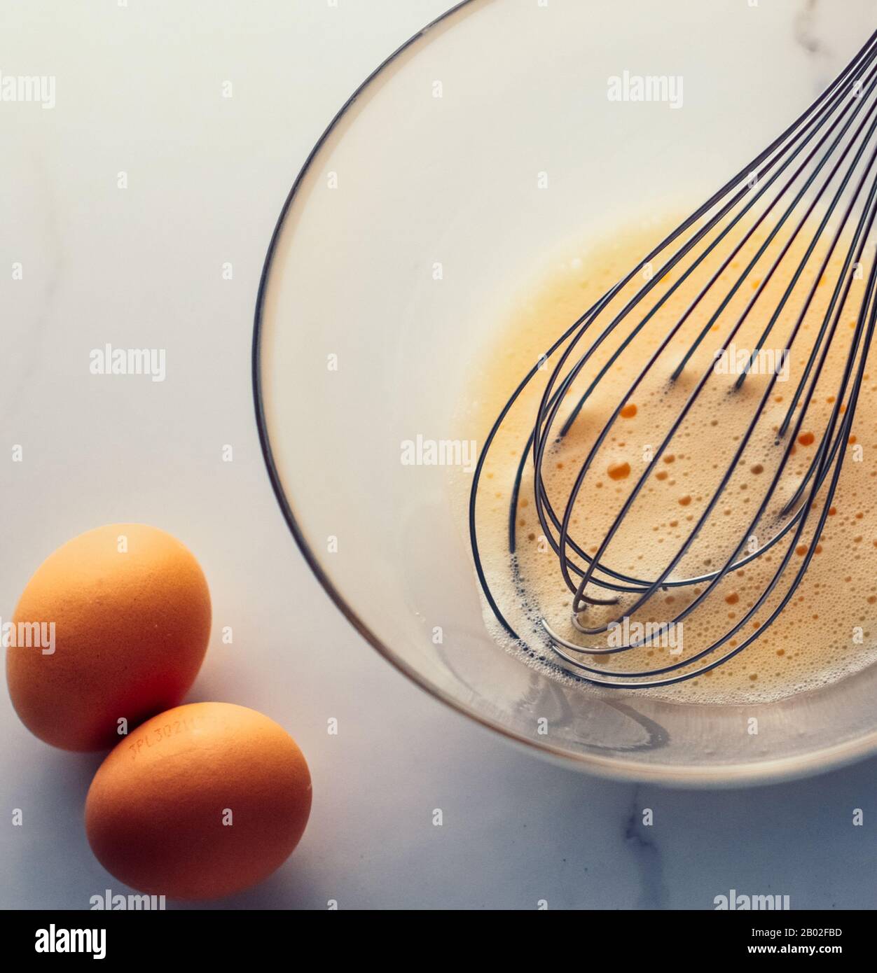 Cooking, meal and diet concept - Making of mixing eggs in bowl on ...